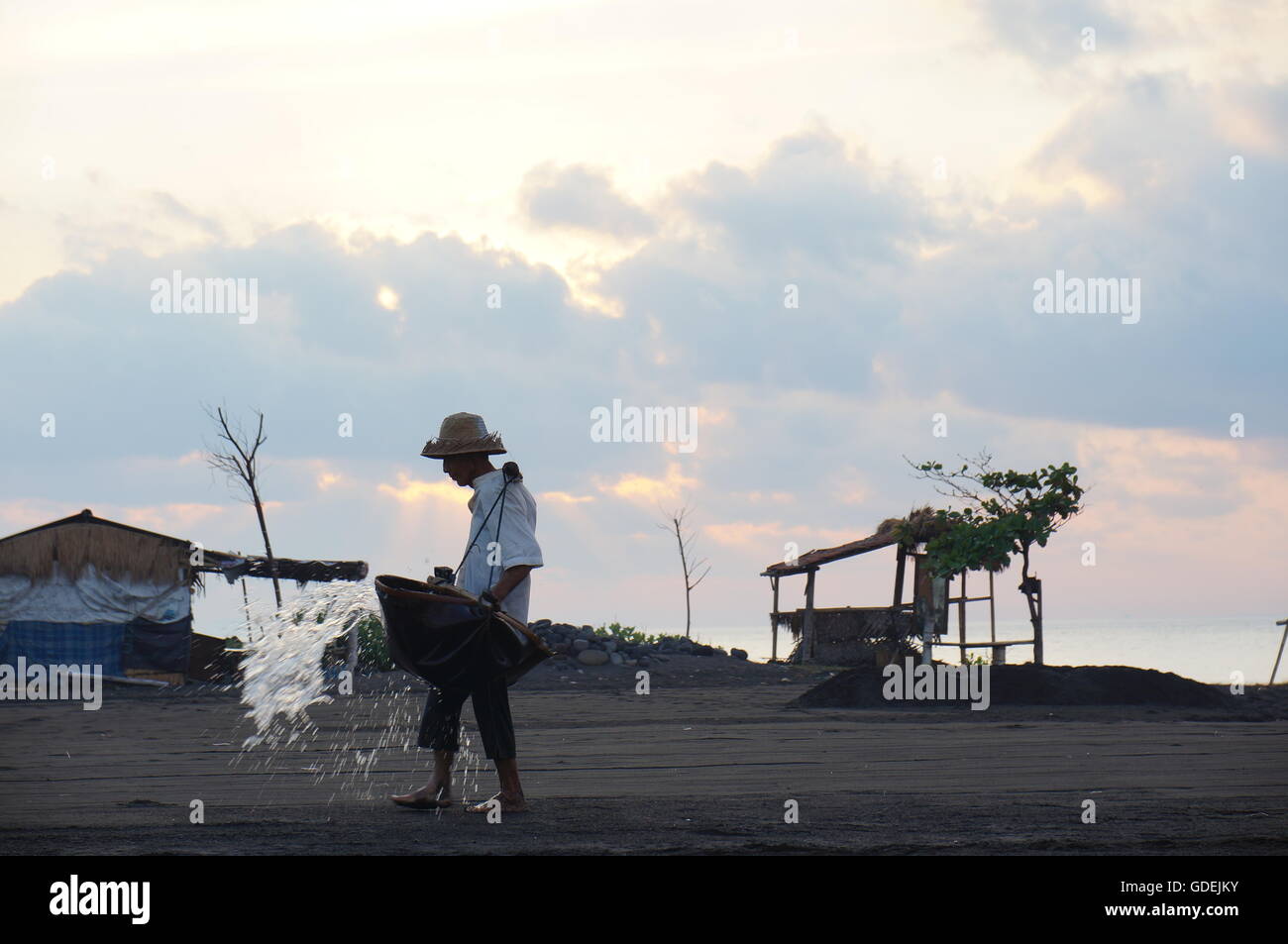 Salt farmer splashing water on the sand, bali, indonesia Stock Photo ...