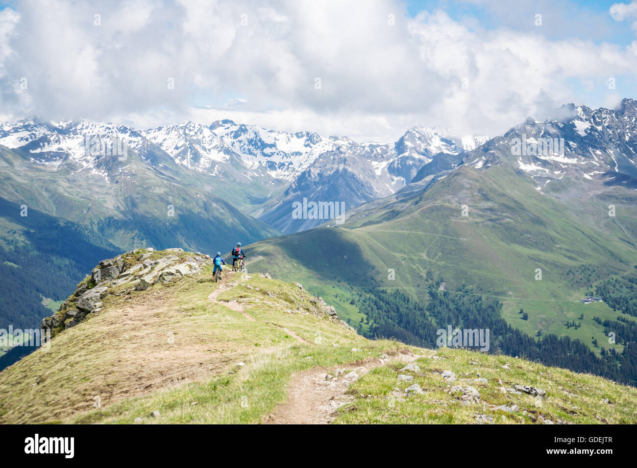 Man and woman mountain biking in swiss alps, Grindelwald, Switzerland ...