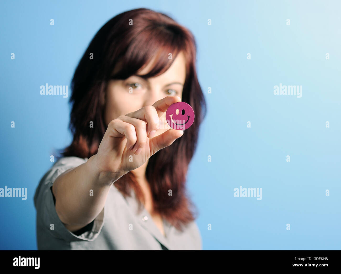 Young Woman holding a smiling emoticon. Focus on smile Stock Photo - Alamy