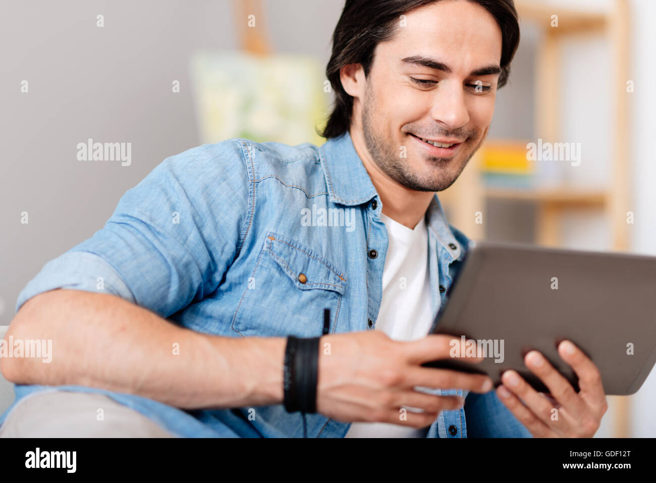 Smiling handsome man using tablet Stock Photo - Alamy