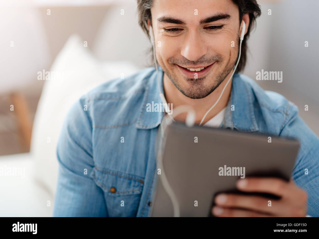 Positive smiling man using tablet Stock Photo - Alamy