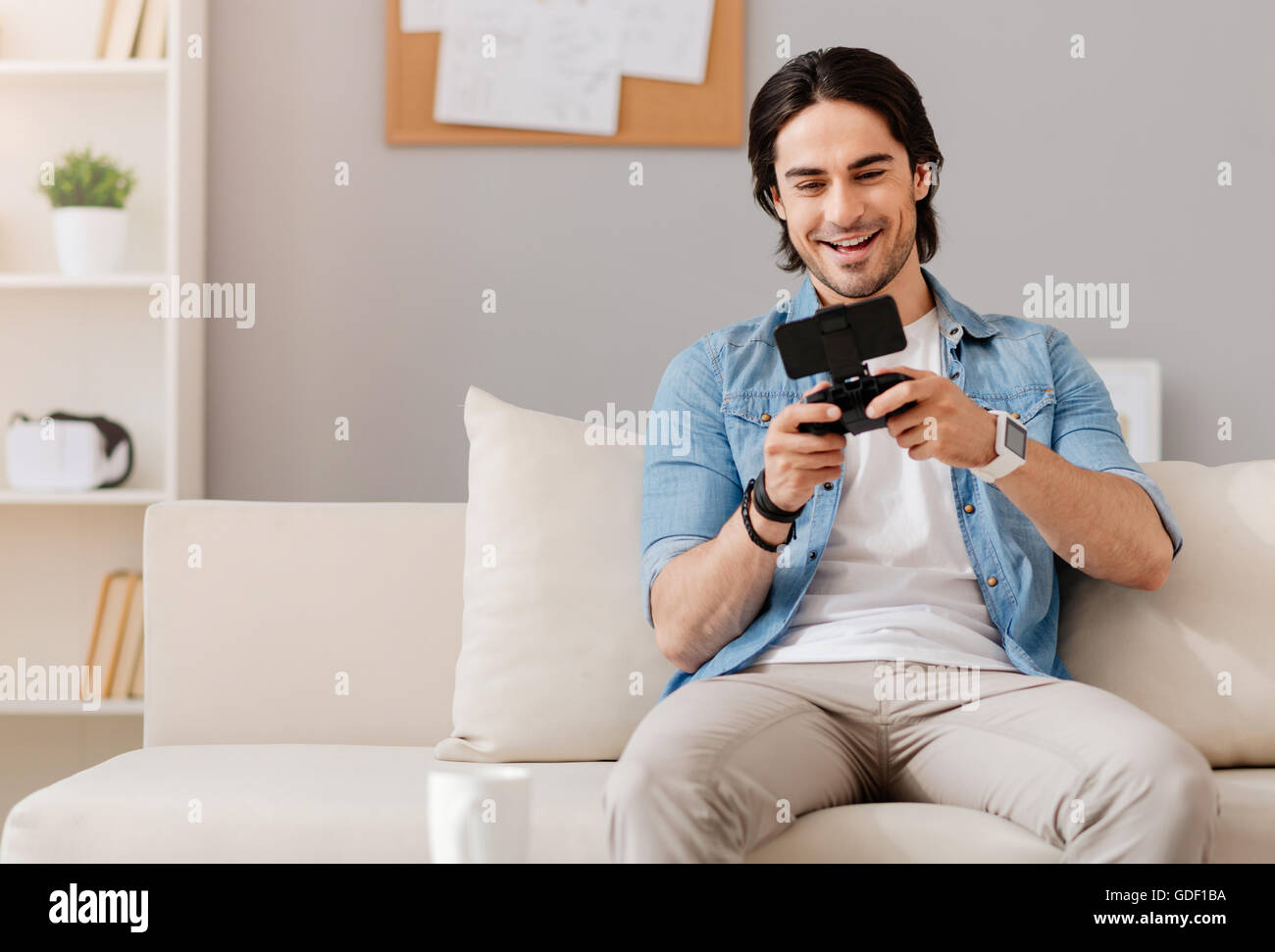 Positive smiling man playing video games Stock Photo - Alamy