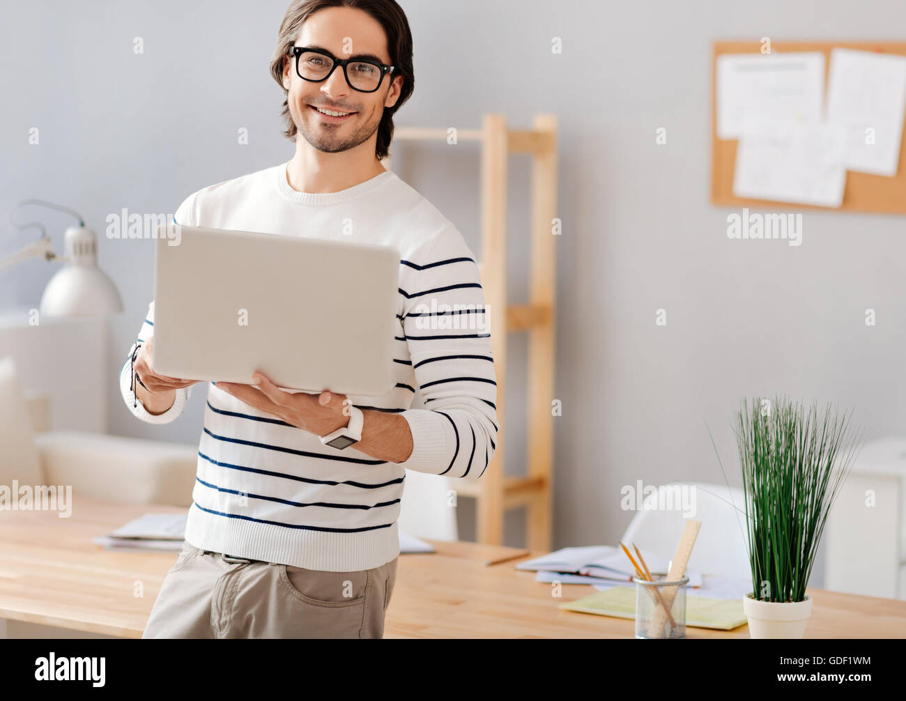 Positive smiling man using laptop Stock Photo - Alamy