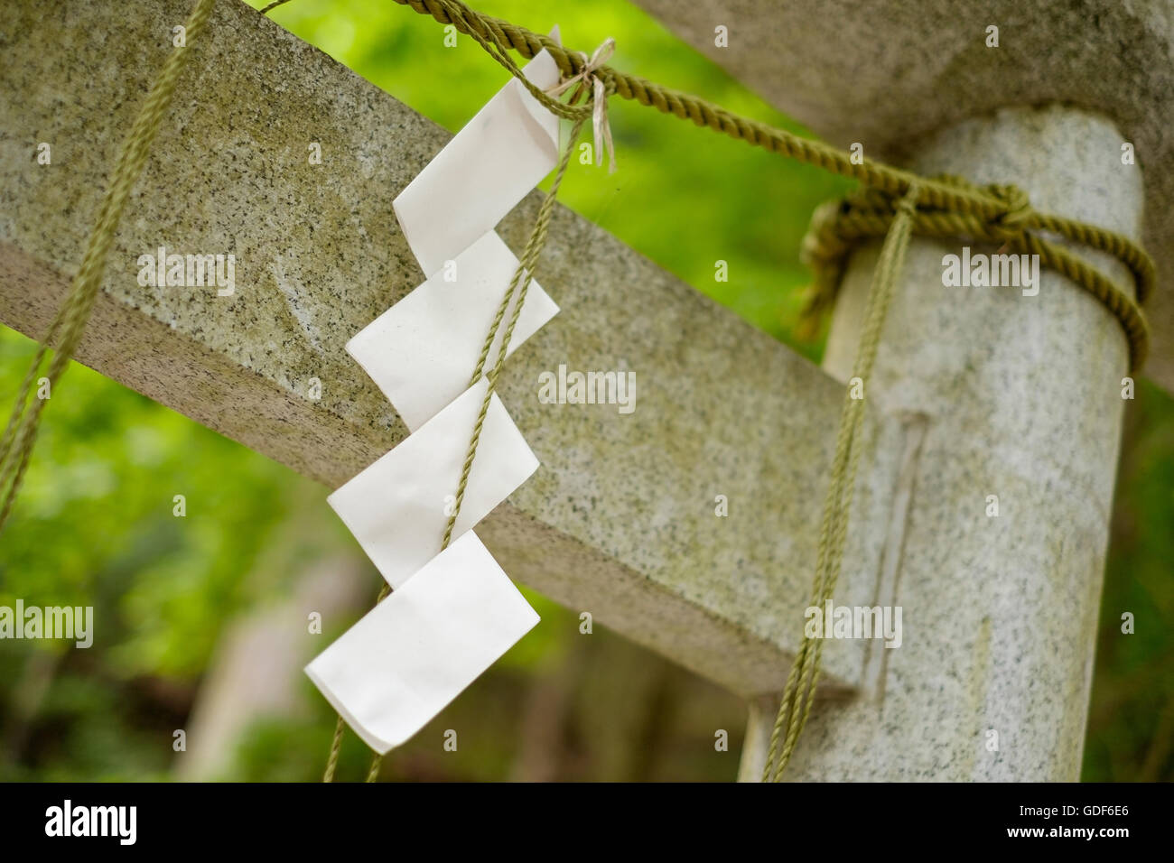 Shide "lightning wand" zig-zags on a stone tori gate outside a Shinto ...