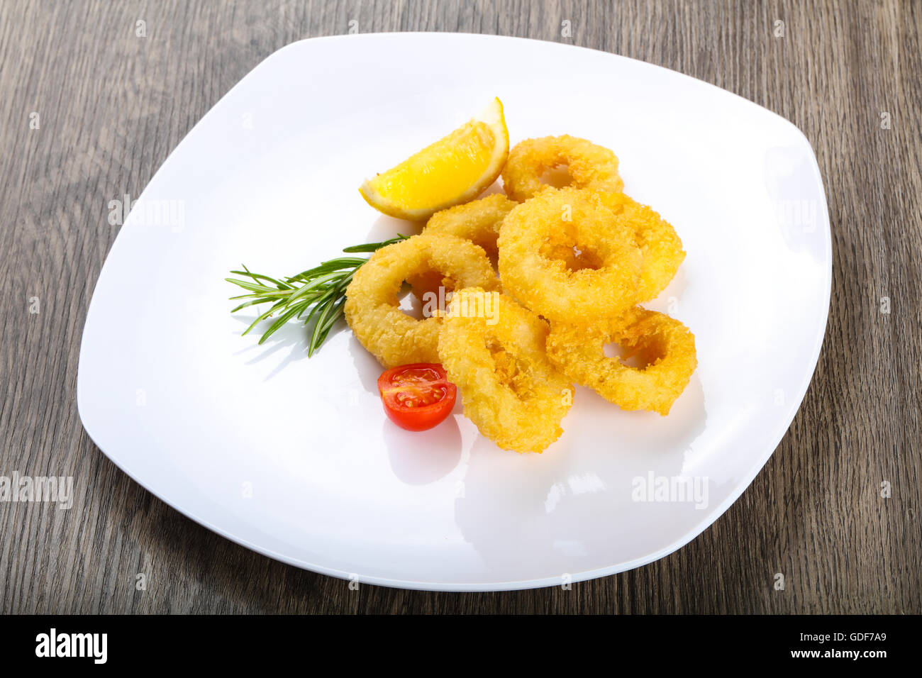 Fried Calamari rings with rosemary and lemon Stock Photo - Alamy