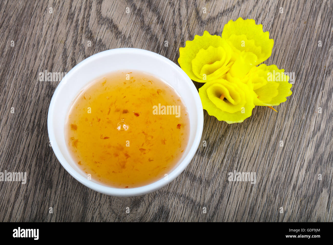 Yellow asian spicy sweet sauce on wood background Stock Photo - Alamy