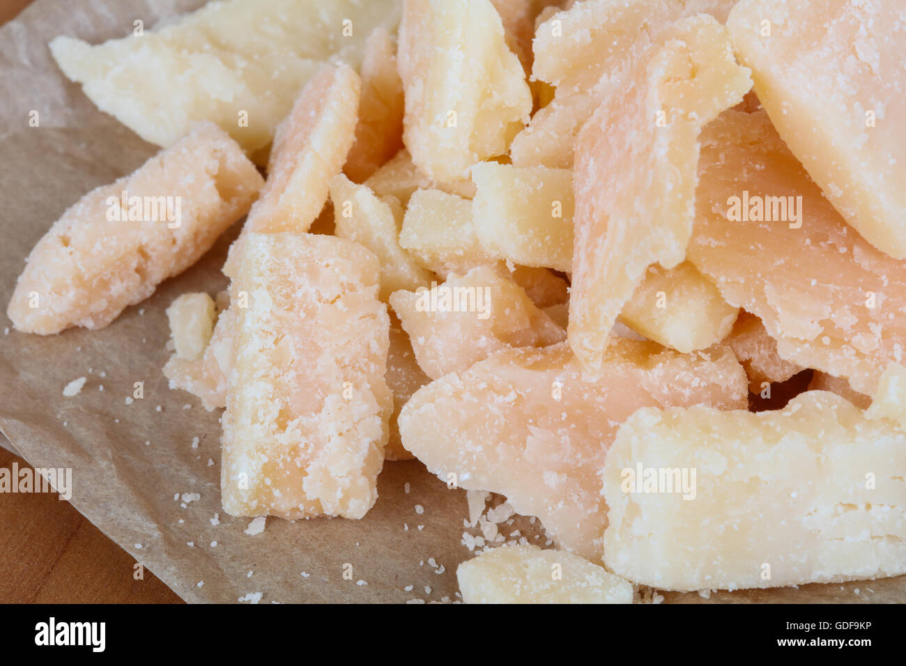 Cutting parmesan cheese crunches on the wood background Stock Photo - Alamy
