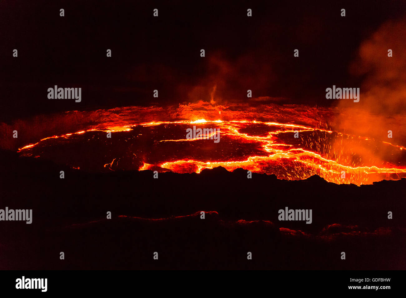 Glowing lava lake with eruptions at night, crater of the active volcano ...