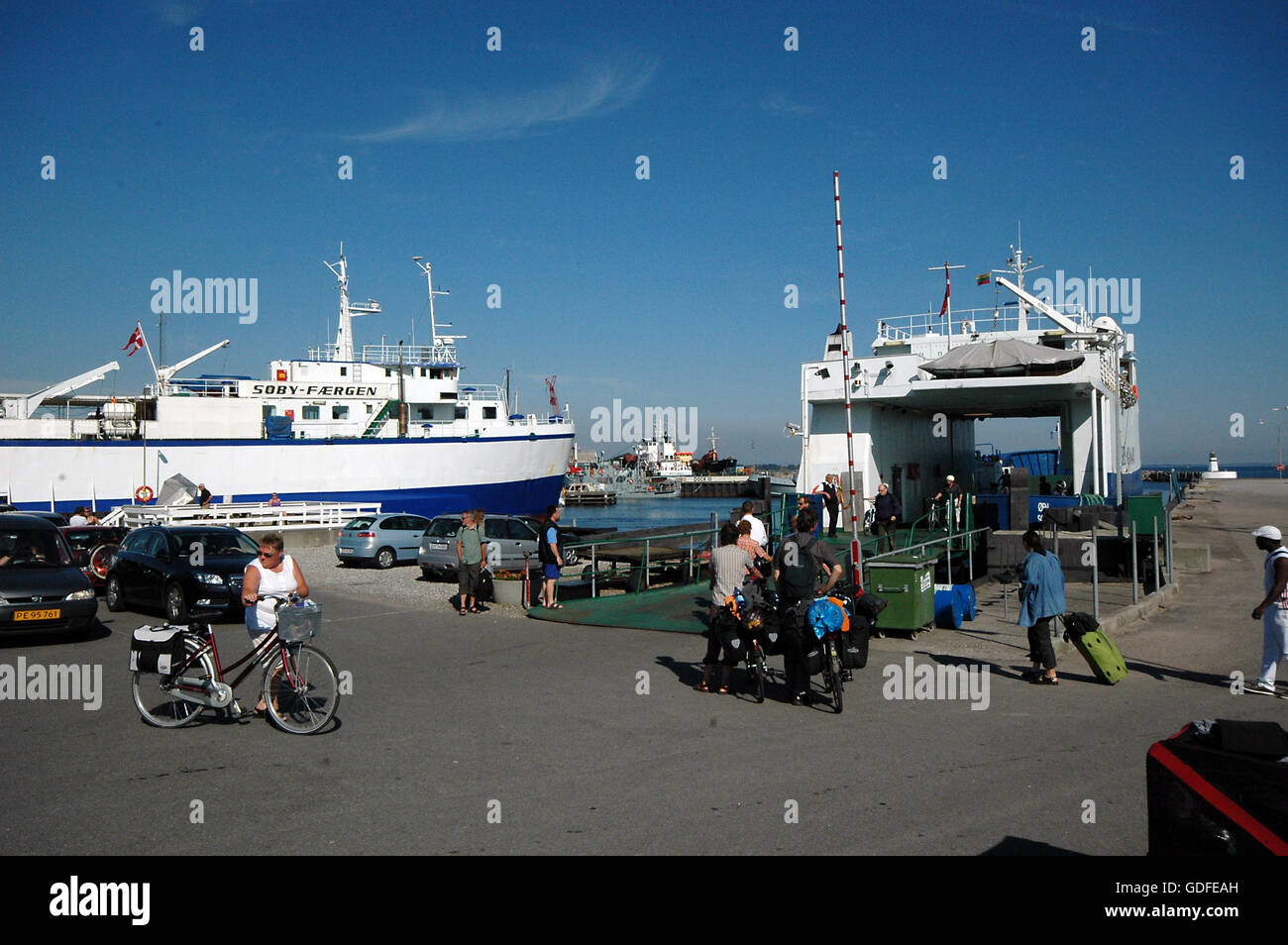 A small ferry line, passengers and cars boarding and leaving the ferry ...