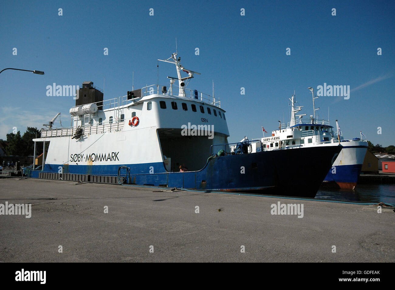 A small ferry line, passengers and cars boarding and leaving the ferry ...