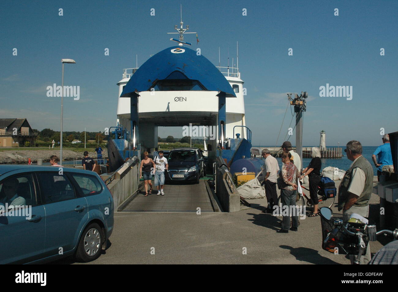 A small ferry line, passengers and cars boarding and leaving the ferry ...