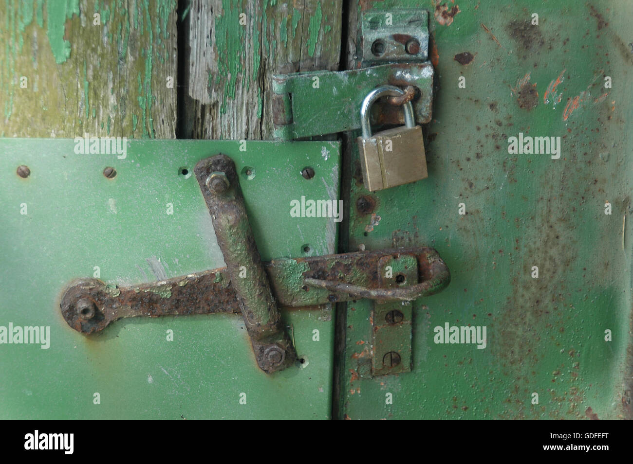 Green door locked with primitive locks Stock Photo - Alamy