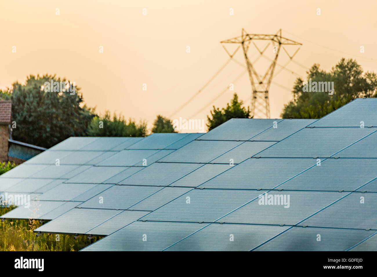 high voltage green pylon and blue photovoltaic panels Stock Photo - Alamy
