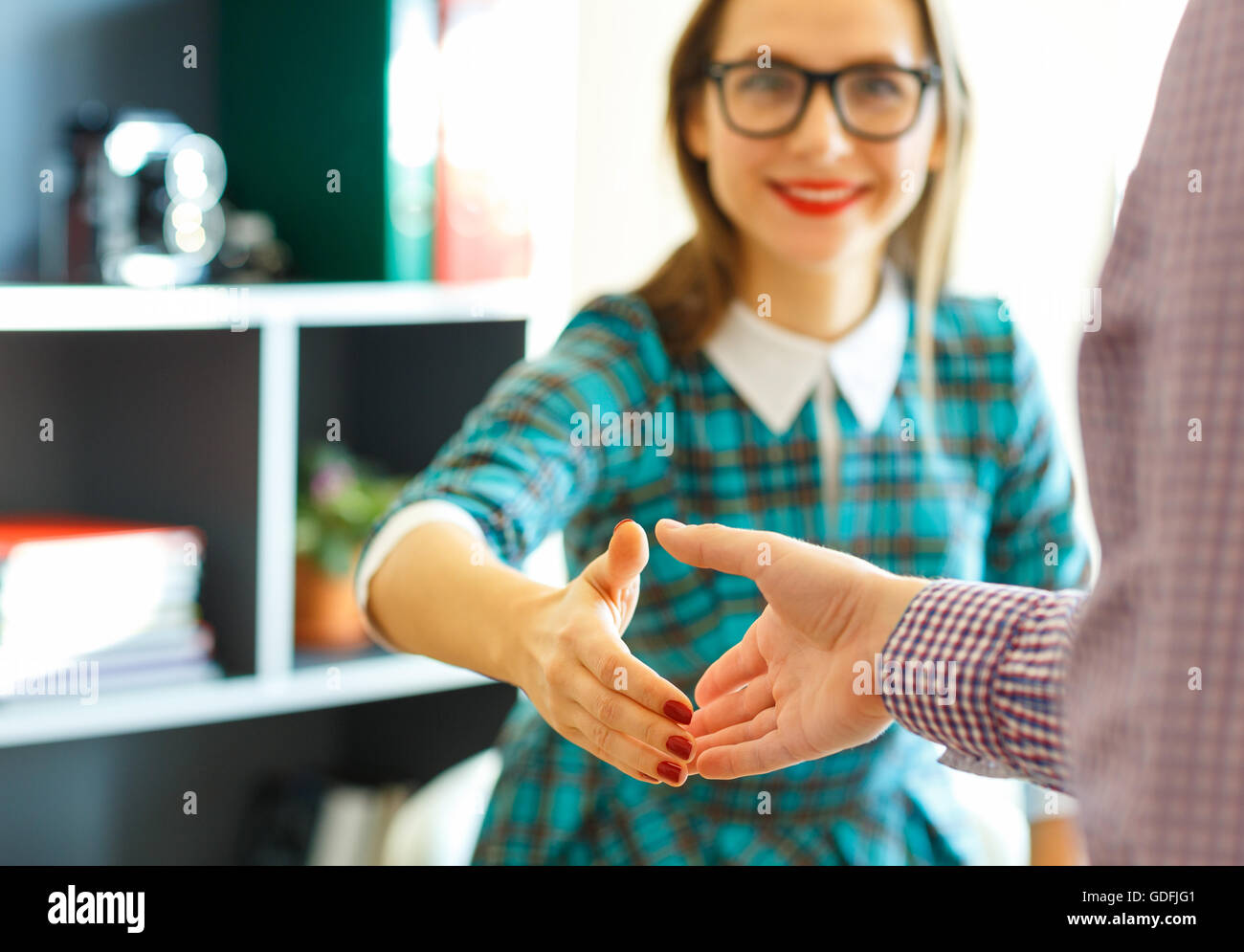 Modern young business woman with arm extended to handshake Stock Photo ...