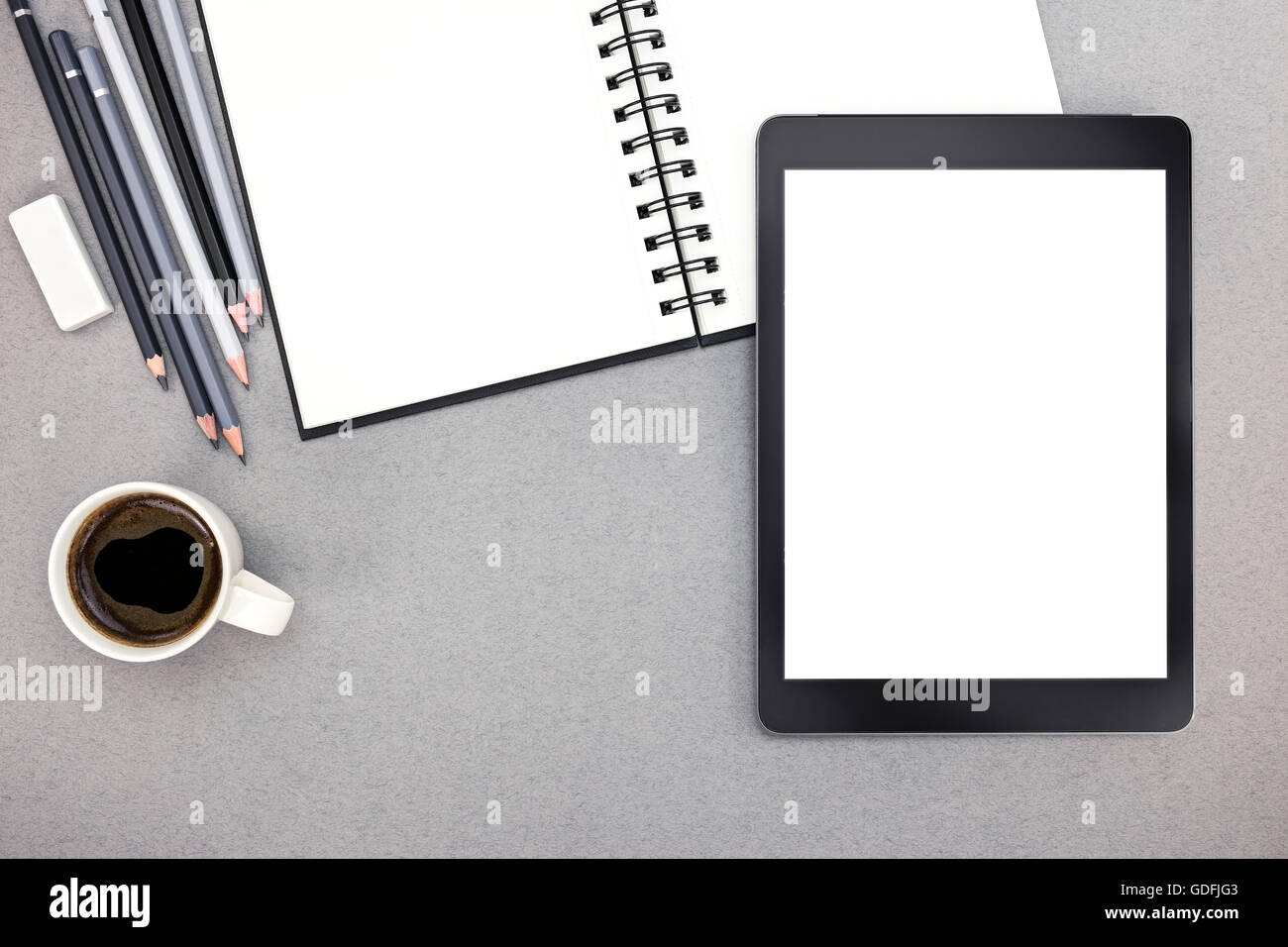 office table with notebook, tablet computer, coffee cup and pencils ...