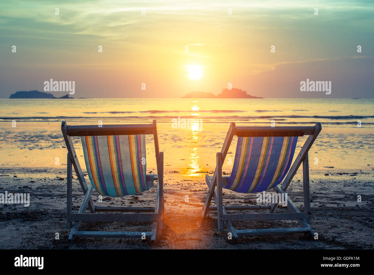 Couple of sun loungers on the beach during sunset Stock Photo - Alamy