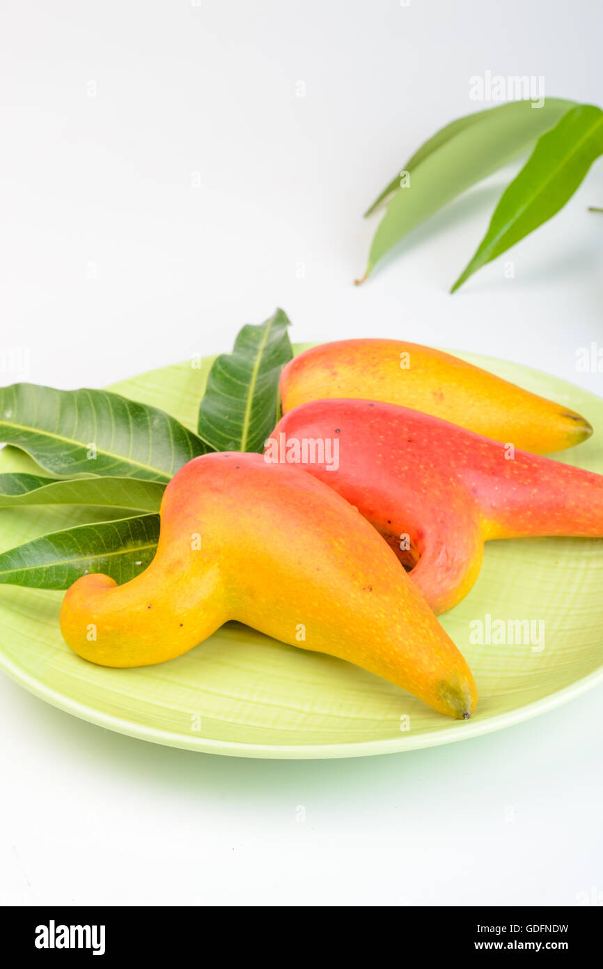 fresh mango and leaves in the plate, it looks like chilli,so called ...