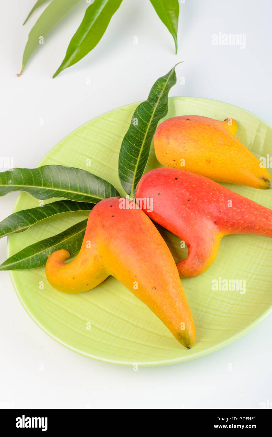 fresh mango and leaves in the plate, it looks like chilli,so called ...