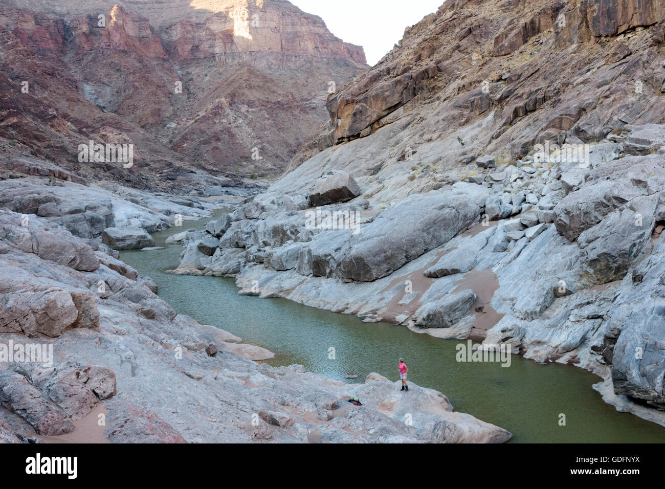 A hiker next to the Fish River along the Fish River Canyon hiking trail ...