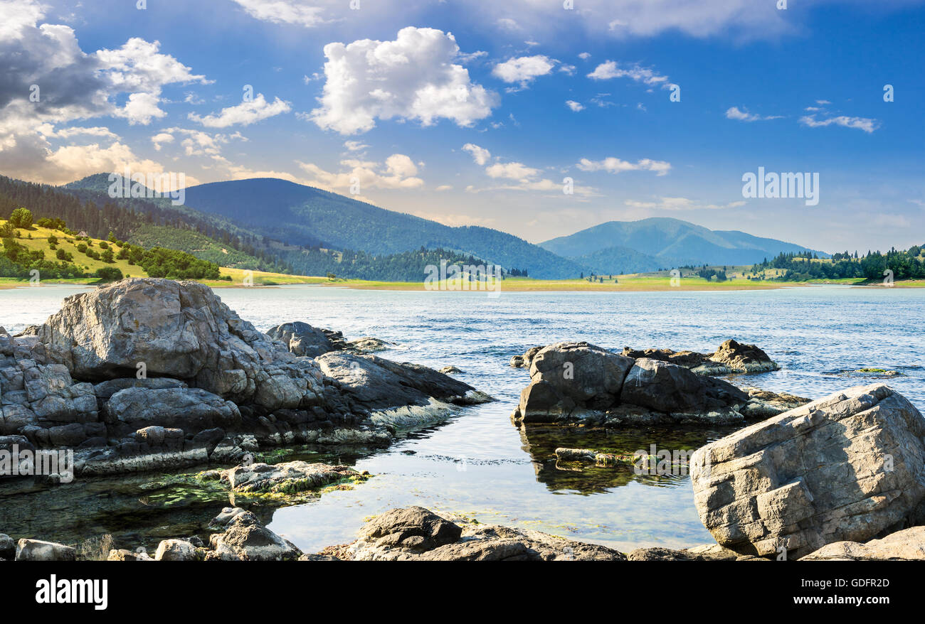 composite landscape with rocky lake shore and some boulders in ...