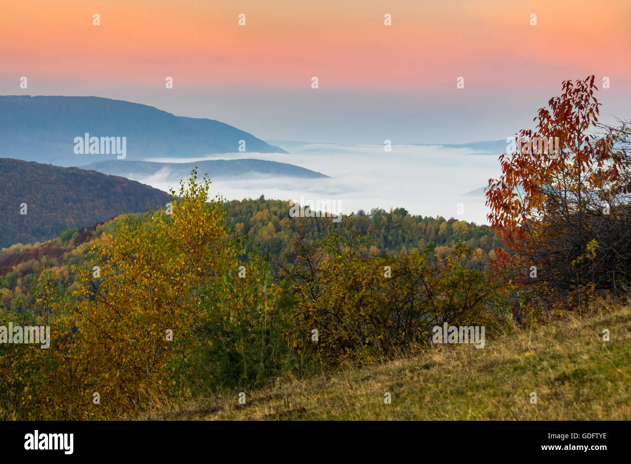 cold morning fog with red hot sunrise in the mountains in the morning ...