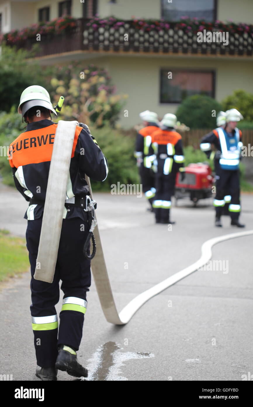 A Fireman with hose over shoulder shoulders Stock Photo - Alamy