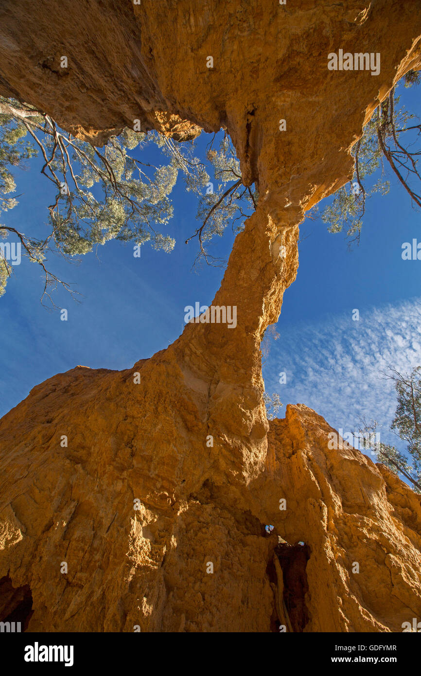 Unusual view from beneath high natural red stone arch with deep blue ...