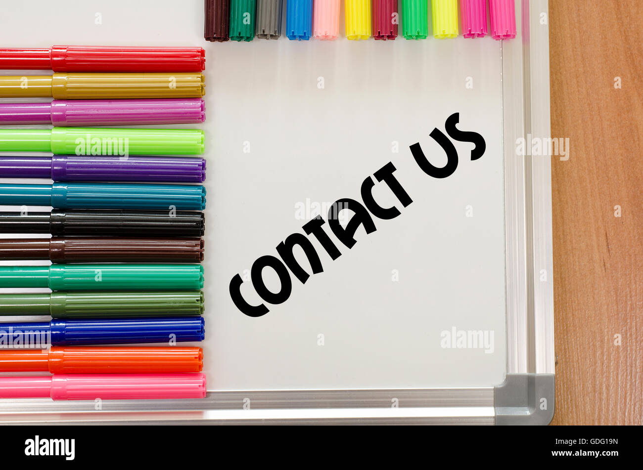 Contact us written on whiteboard over wooden background Stock Photo - Alamy