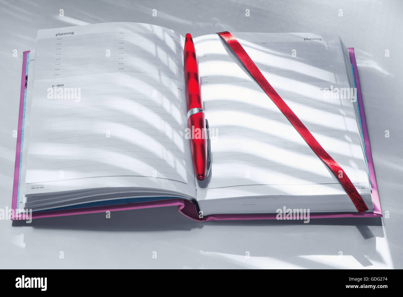 Notebook and pen on window sill with light shade from blinds Stock ...