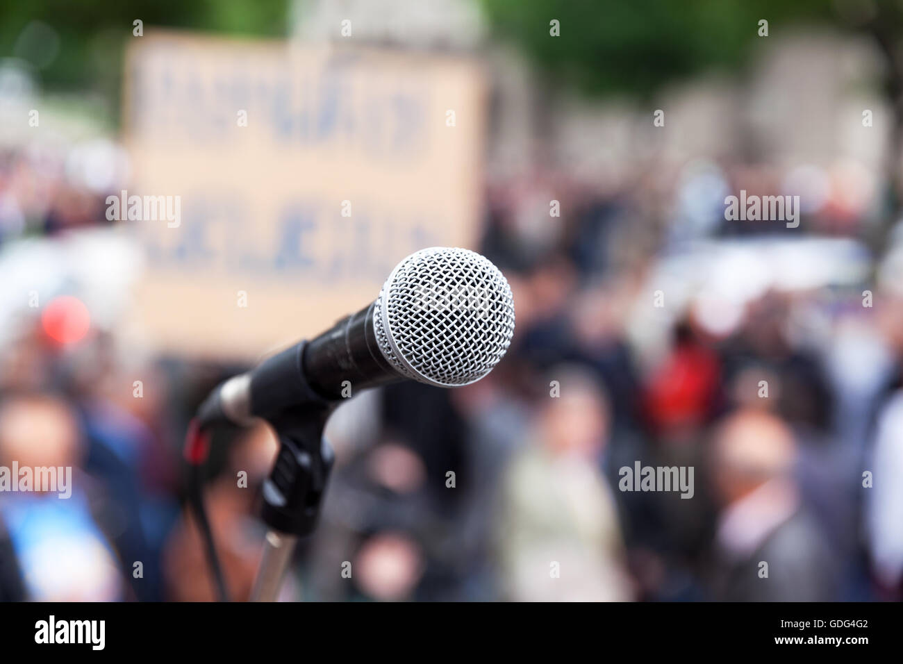 Microphone in focus against blurred crowd. Political rally Stock Photo ...