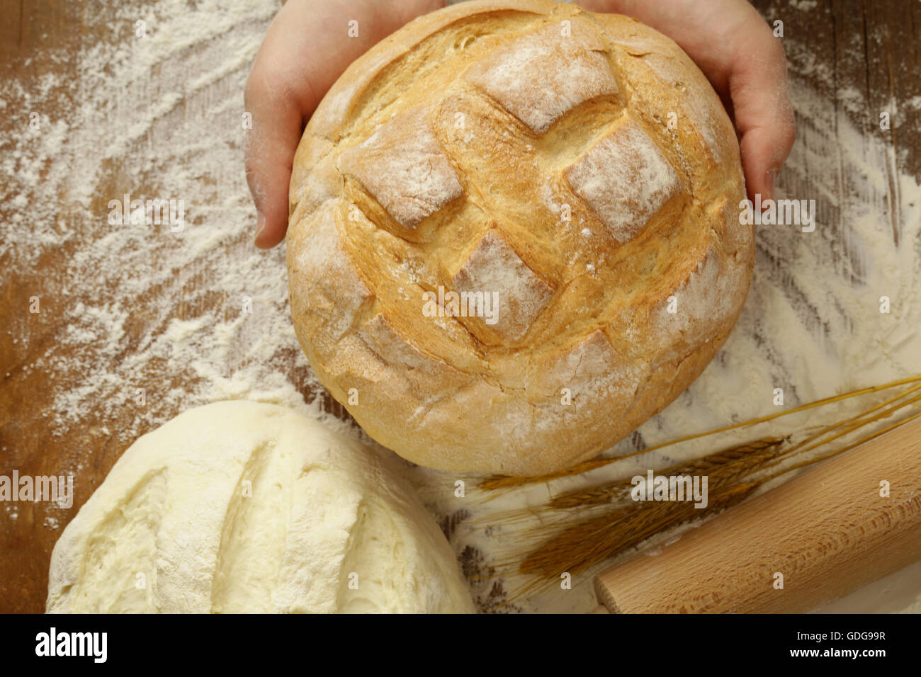 Chef hands with dough and homemade natural organic bread and flour on a ...