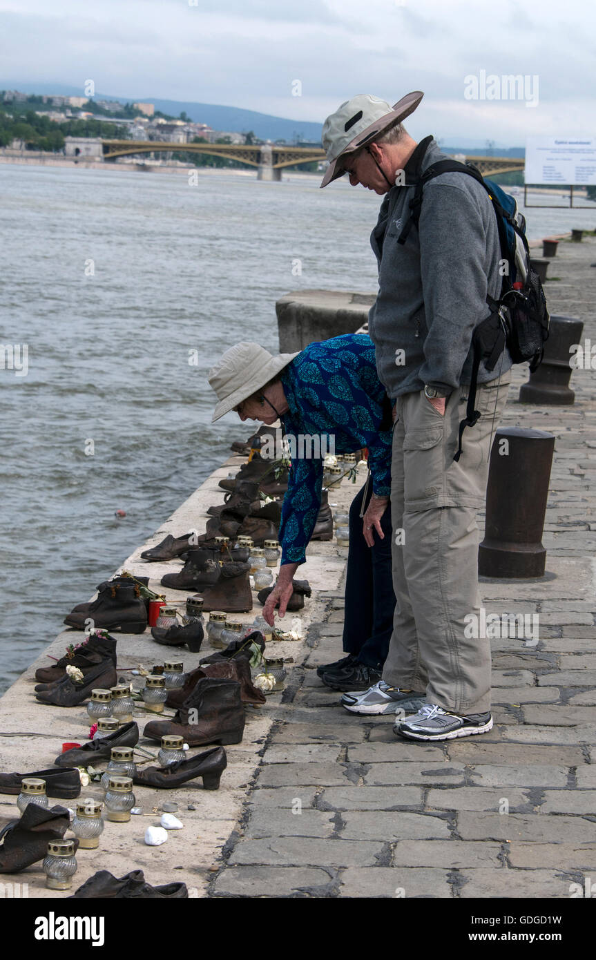 A couple of visitors by the metal shoes on the Danube Promenade beside ...