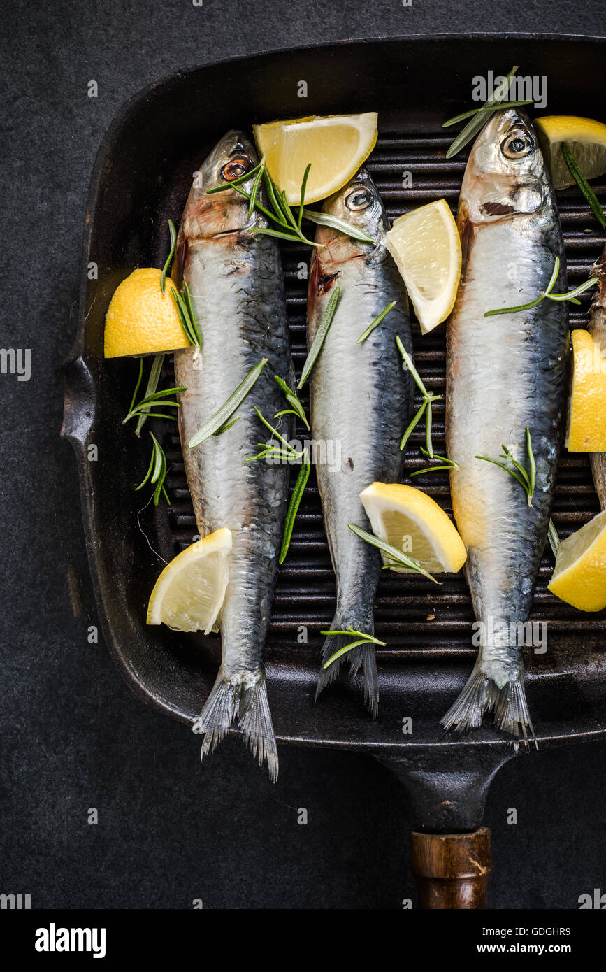 frying fish with lemon and herbs on vintage pan Stock Photo - Alamy