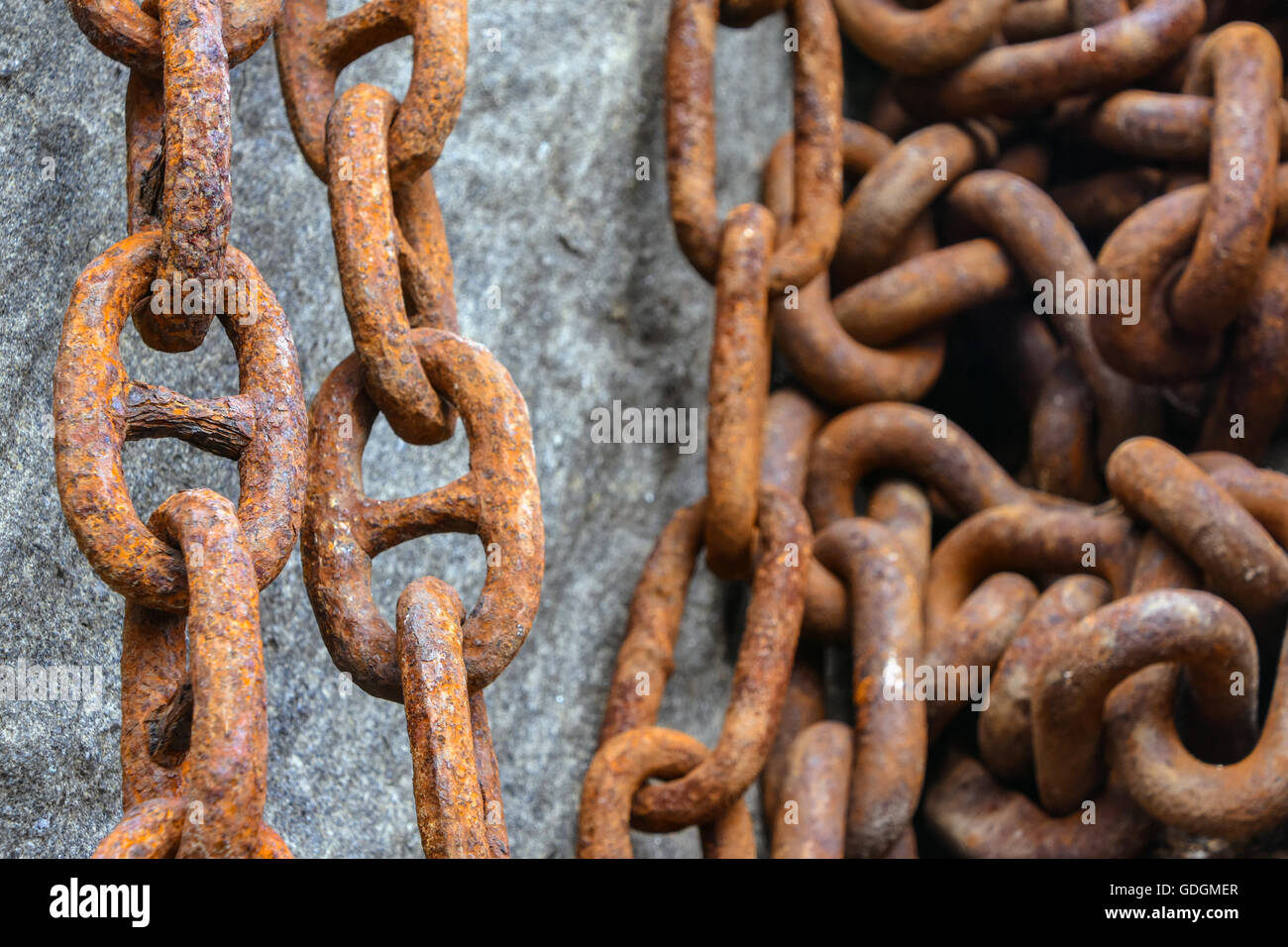 Thick rusty iron chains against granite rock Stock Photo - Alamy
