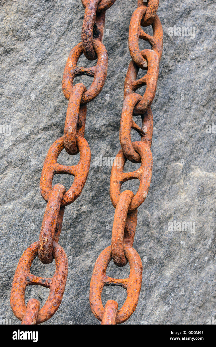 Thick rusty iron chains against granite rock Stock Photo - Alamy