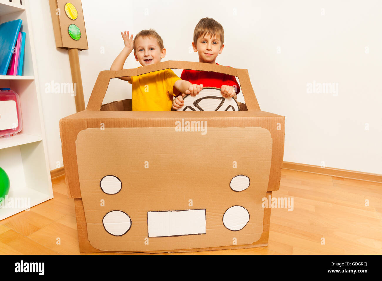 Two boys driving toy handmade cardboard car Stock Photo - Alamy