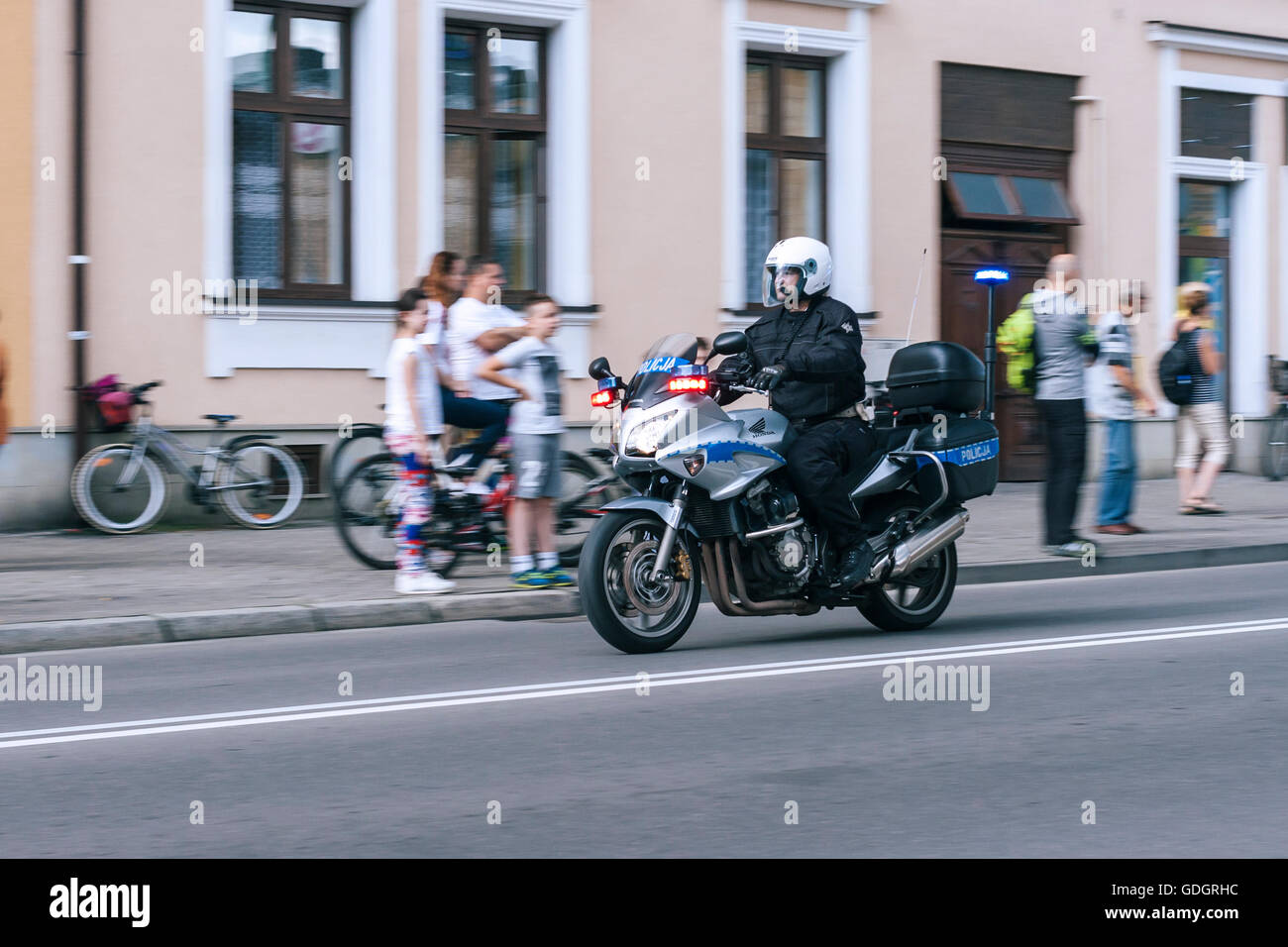 Polish Police motorcycle quickly passing people watching the parade in ...