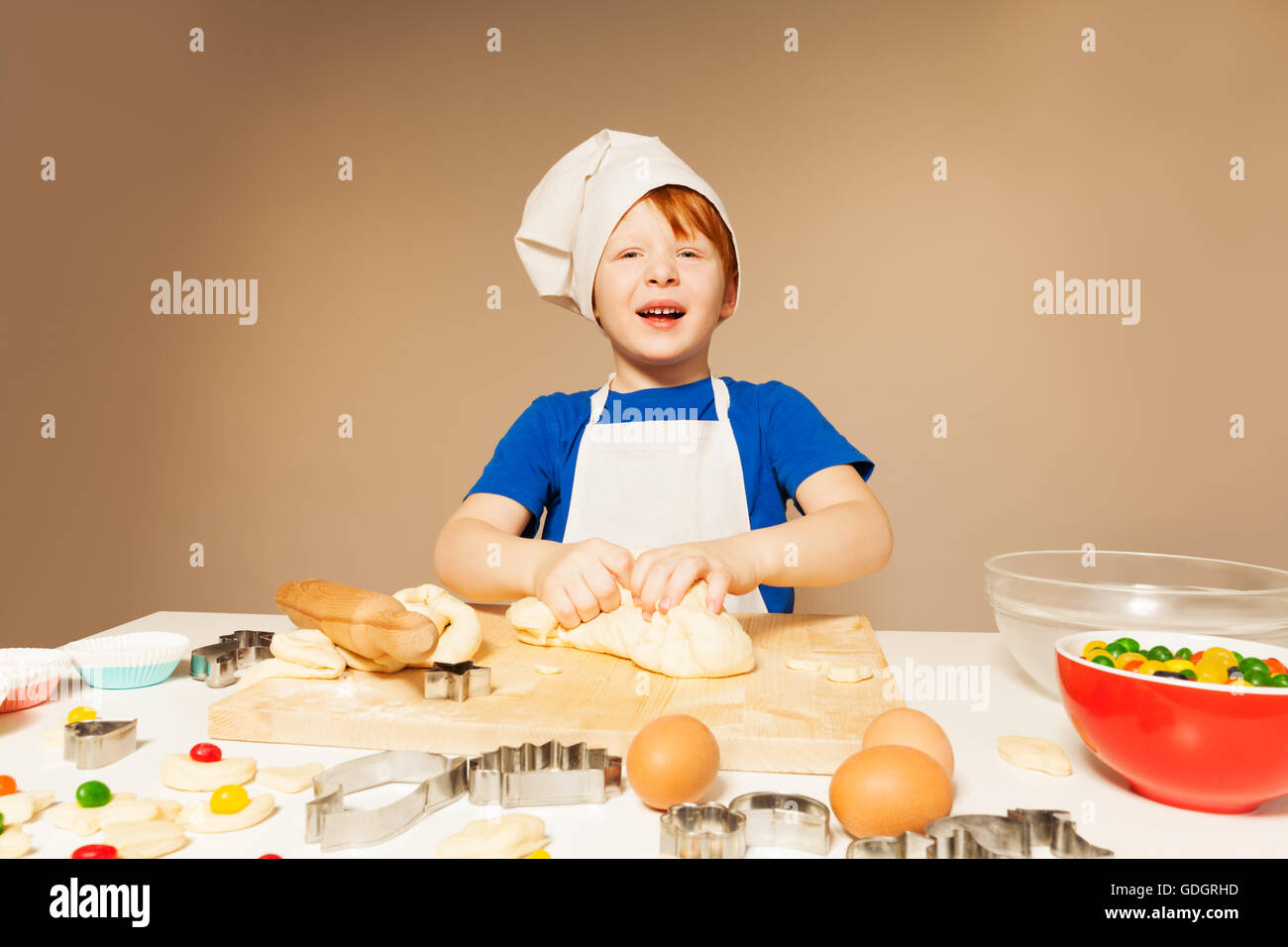 Cute baker kneading dough for candy filled cookies Stock Photo - Alamy
