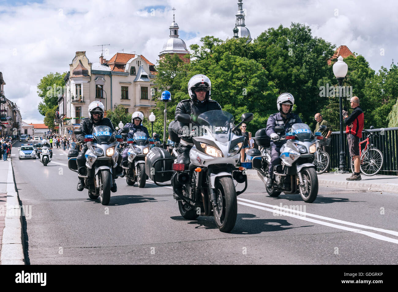 Polish police motorcycle convoy on a bridge with a view of the old town ...
