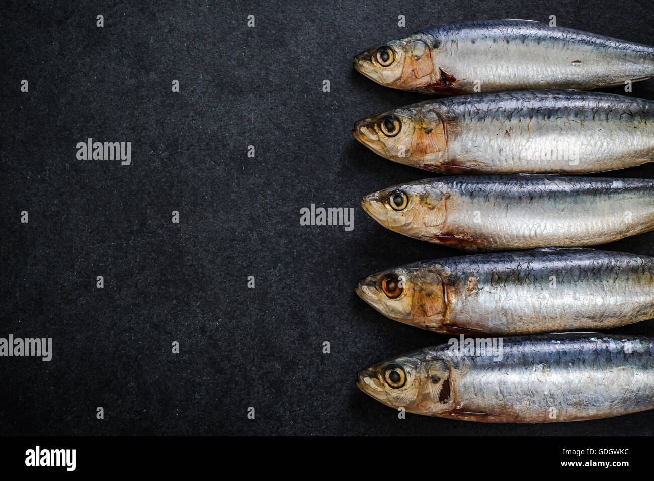 whole sardin fish on dark slate background Stock Photo - Alamy