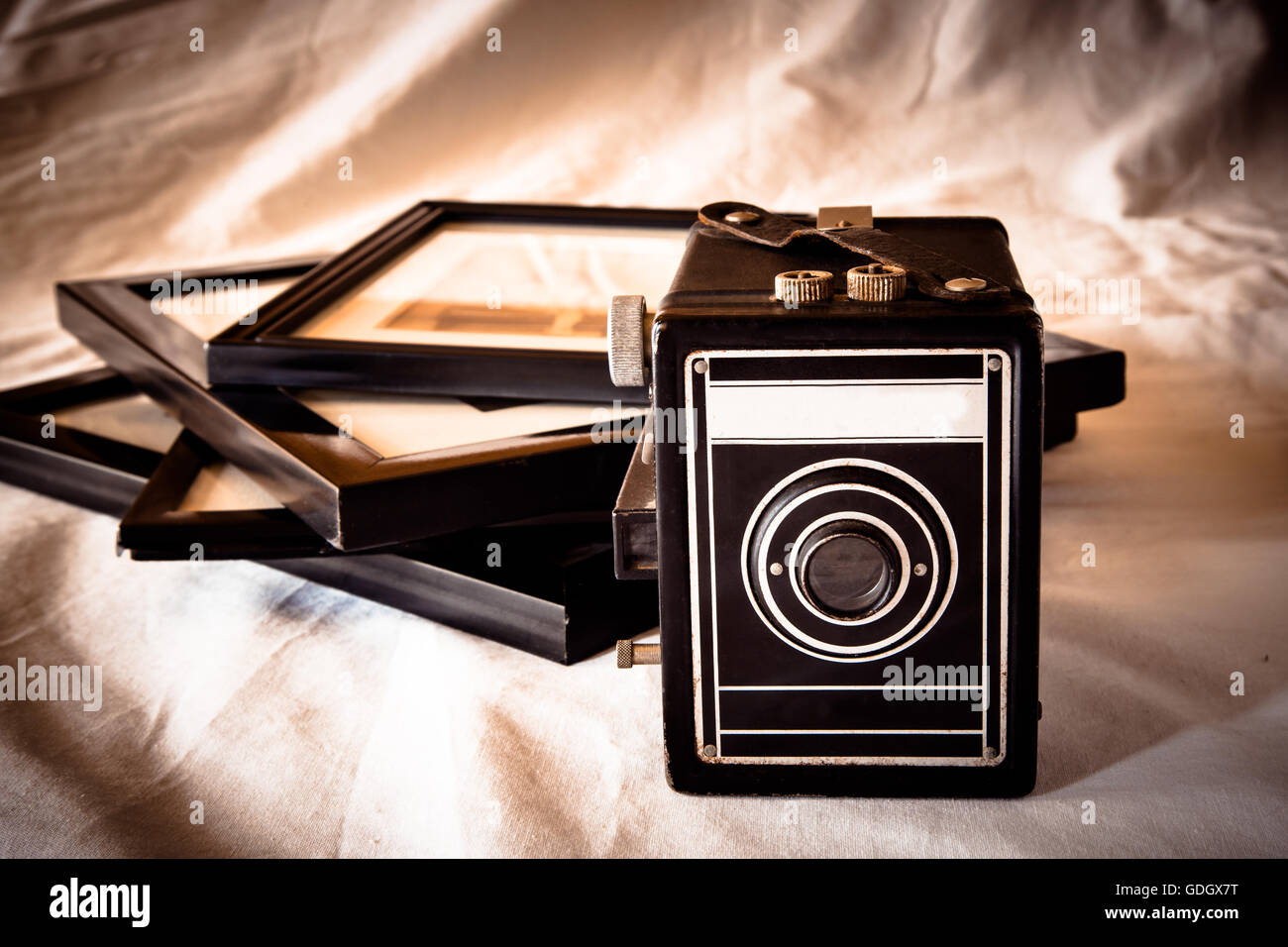 Vintage style film box camera with framed photographs and retro tone ...