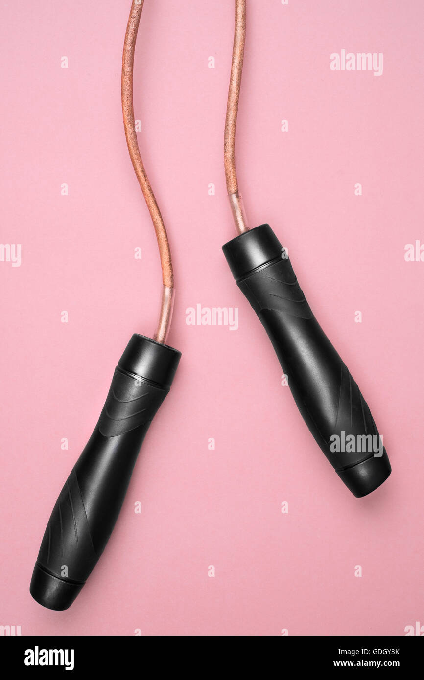 close-up wooden handles of skipping rope isolated on pink background ...