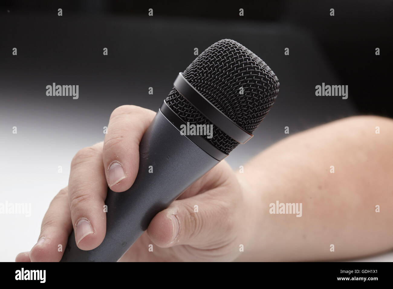 Microphone in a man's hand Stock Photo - Alamy
