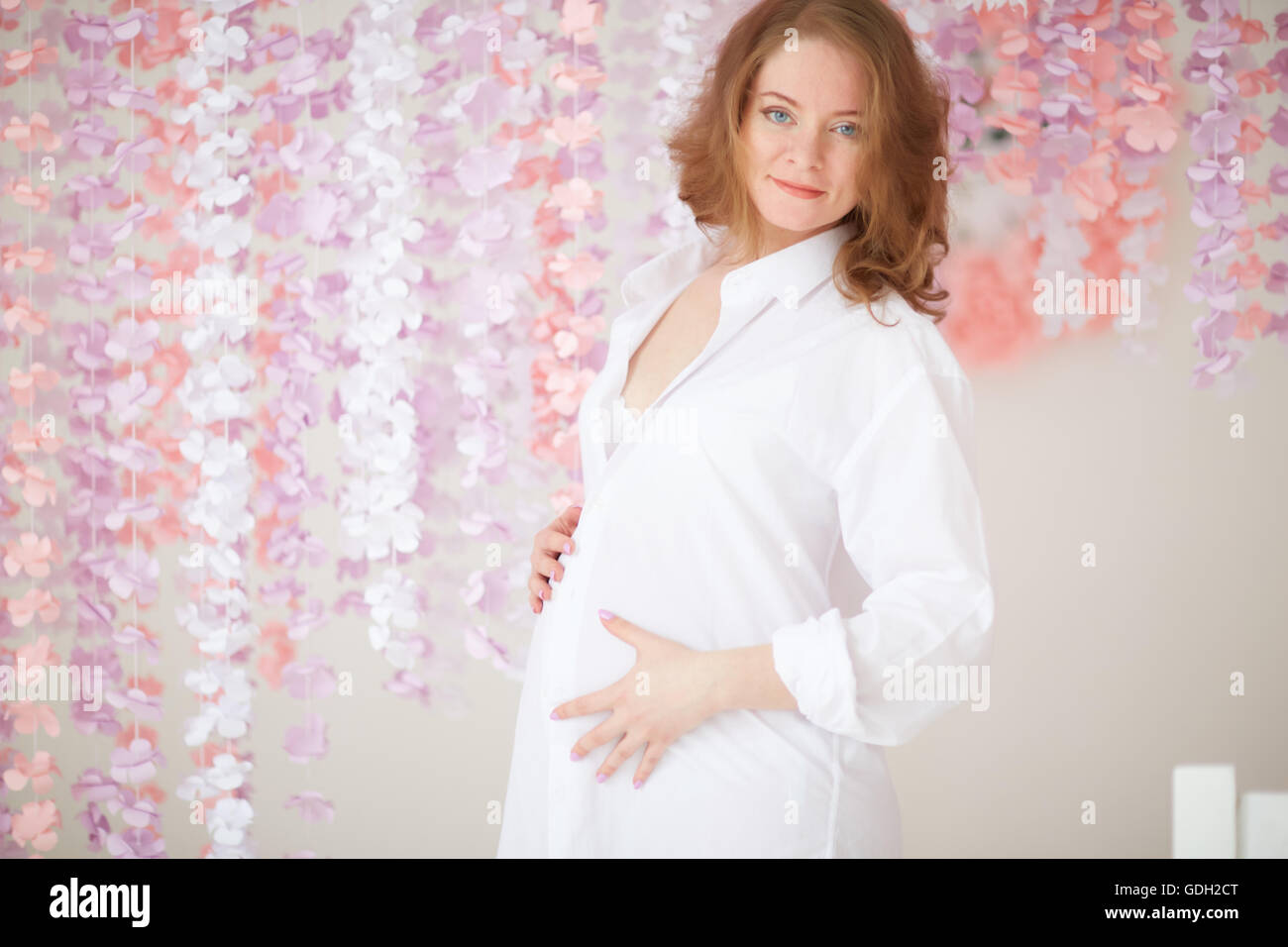 pregnant woman in pink on a background of flowers Stock Photo - Alamy