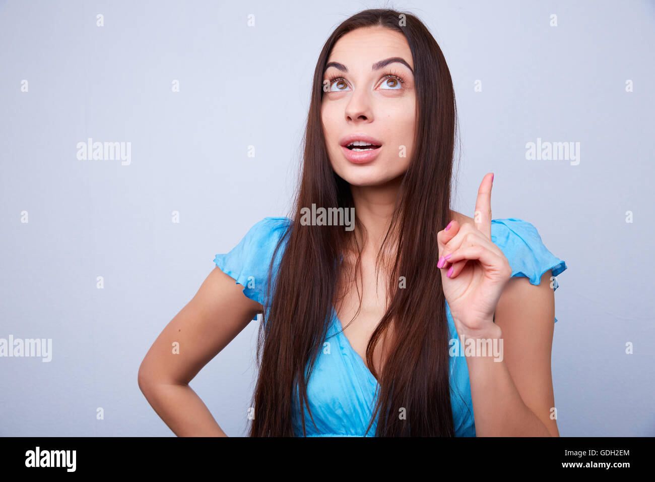 Brunette thought lifting a finger up Stock Photo - Alamy