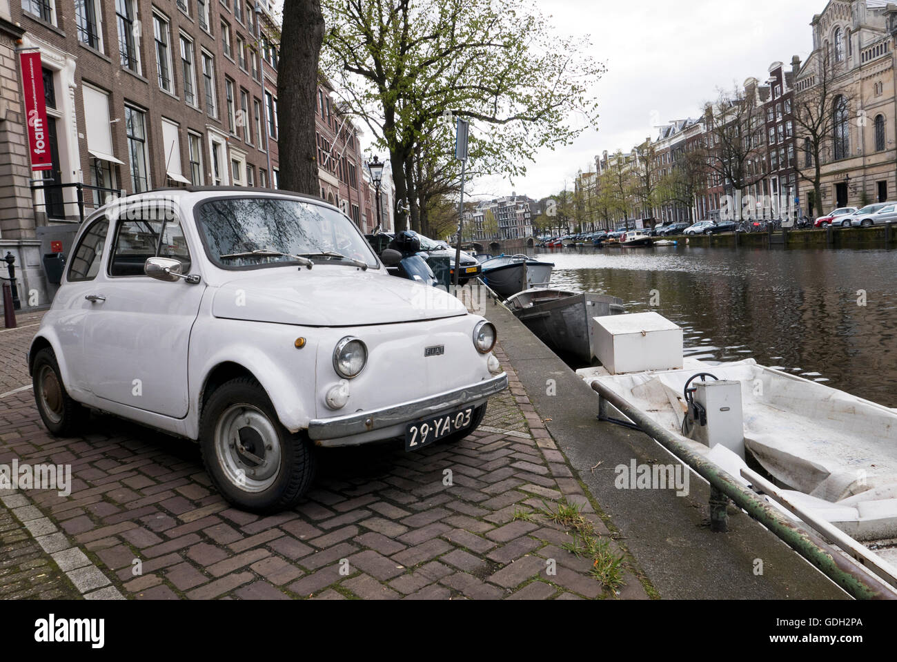 A small Fiat car parked by the canal in Amsterdam, Holland, Netherlands ...