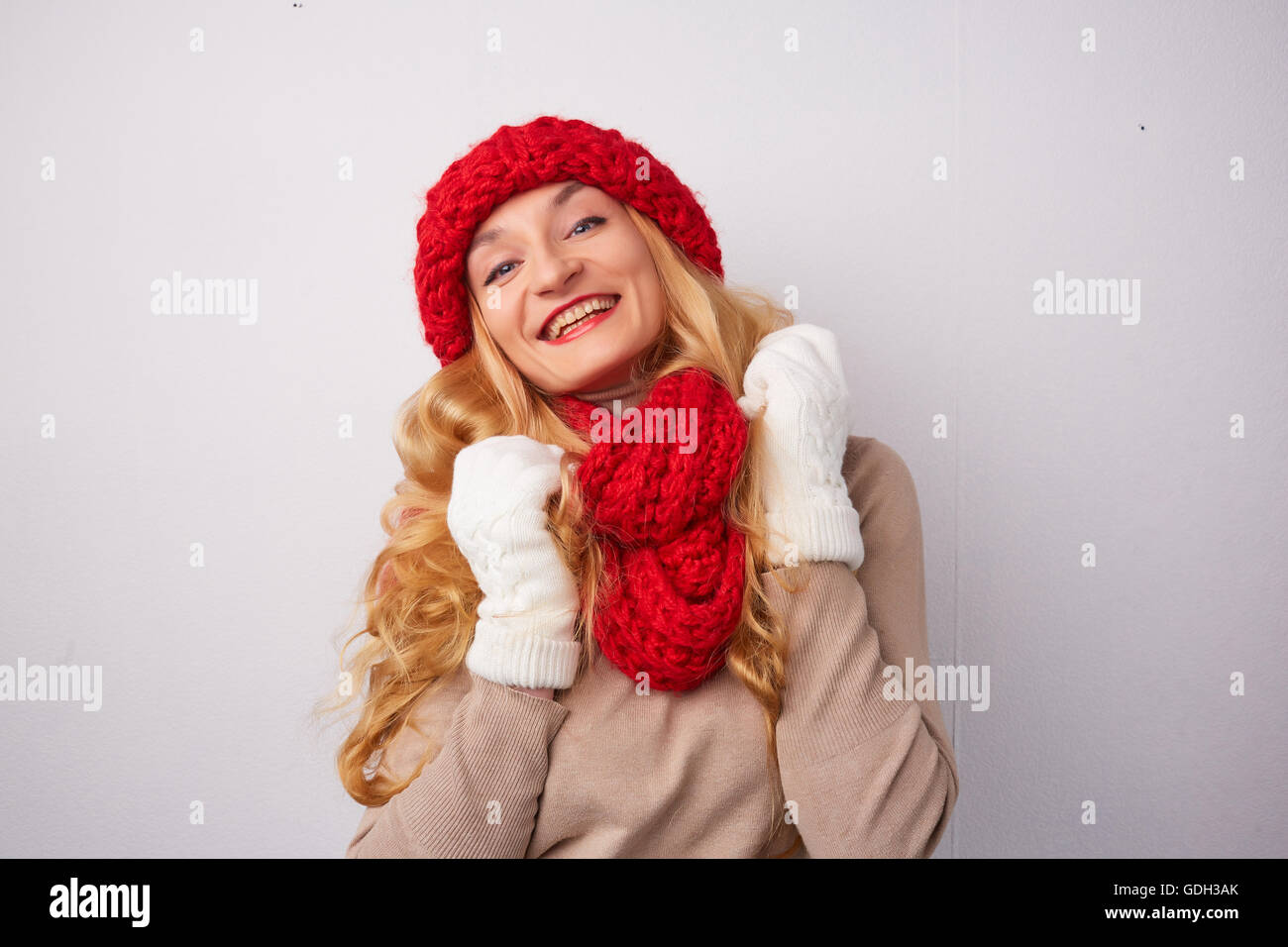 blonde in a red hat and scarf smiling Stock Photo - Alamy