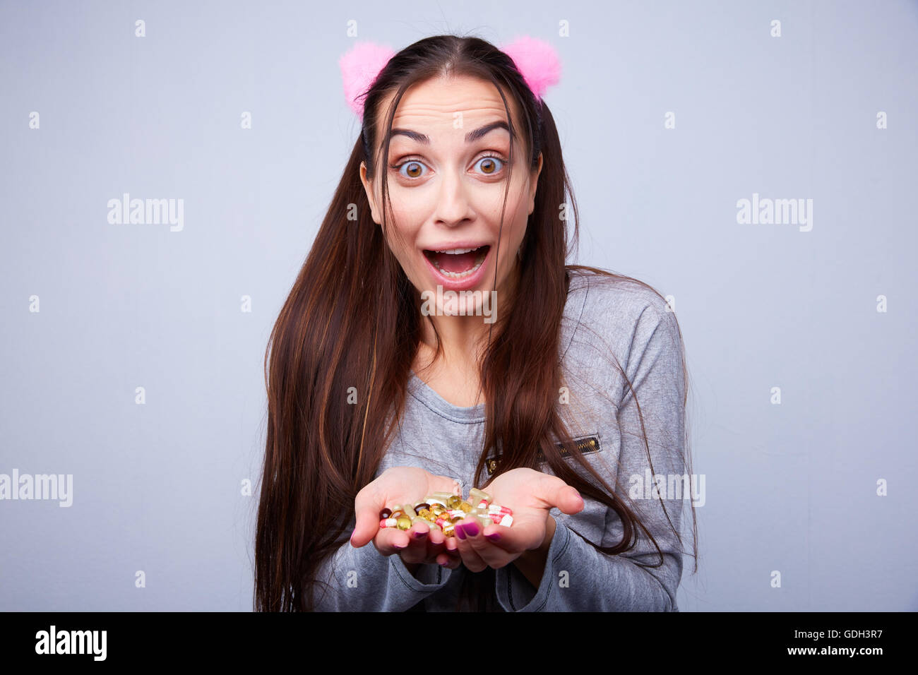 fun girl drinks a lot of pills Stock Photo - Alamy