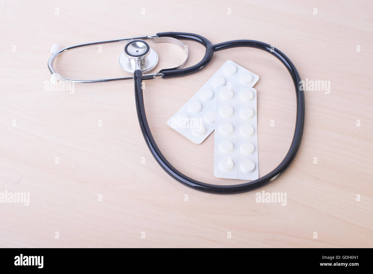 Stethoscope with tablets in blister packs on wooden background. Medical ...