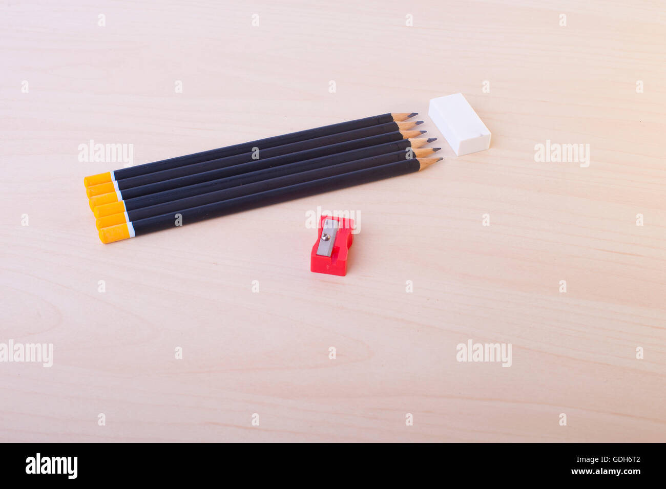 Pencils, rubber eraser and a sharpener on a wooden background Stock ...